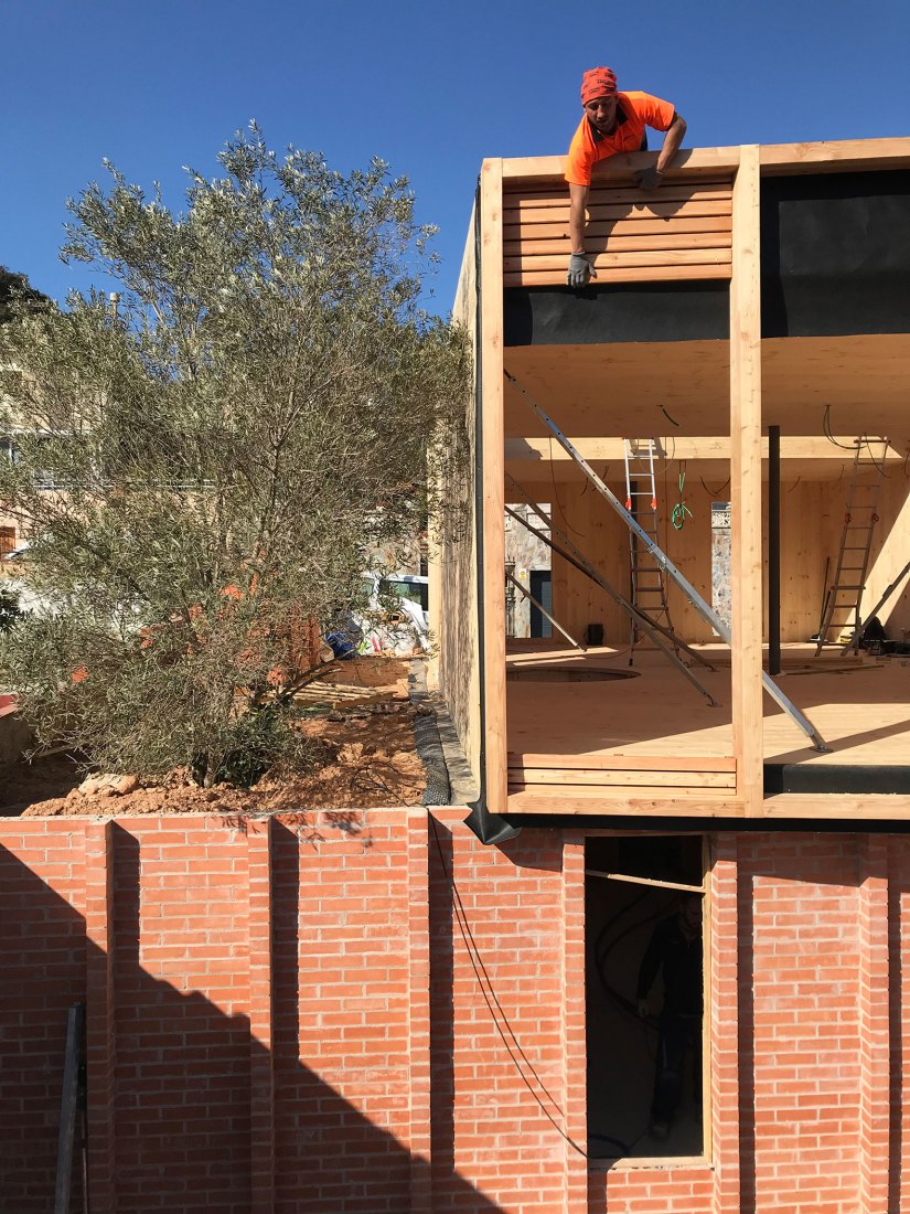 Conectando el cielo y la tierra. Casa sobre un zócalo de ladrillo por ...