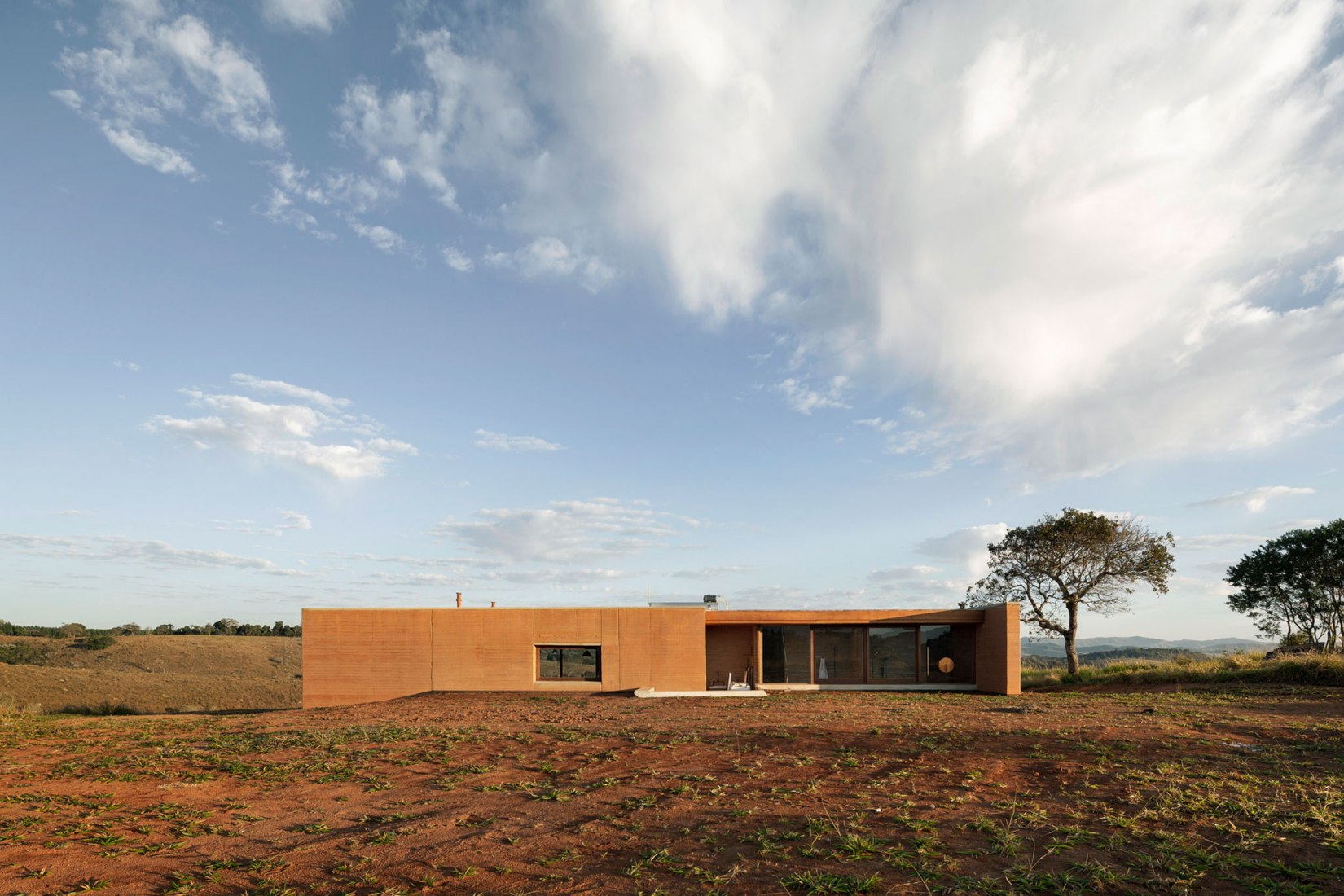 A house emerged from the red lands and the Cunha rolling landscape by ...