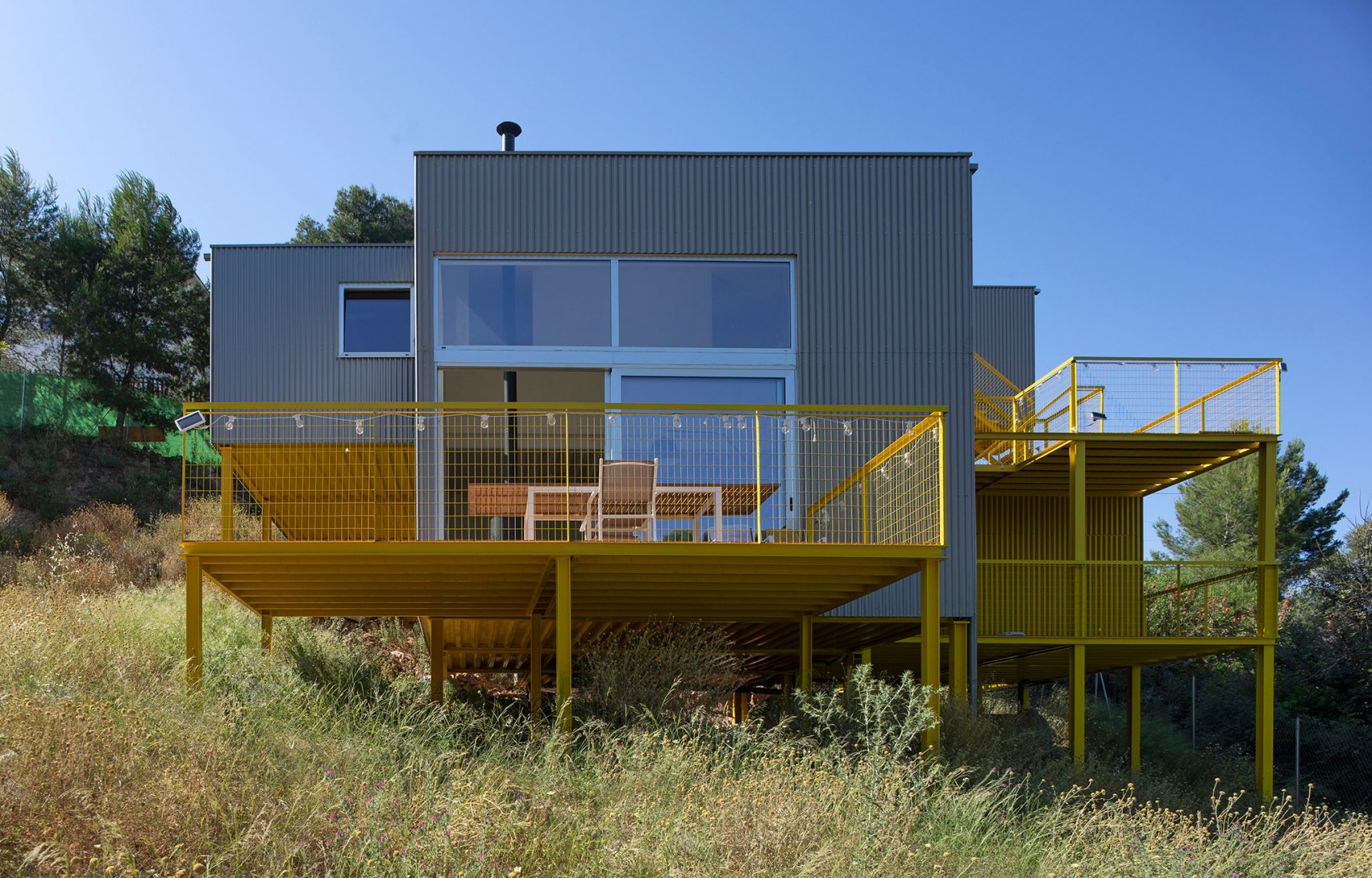 A fragmented house on a slope. rNrH industrialized home by Juan Marco ...