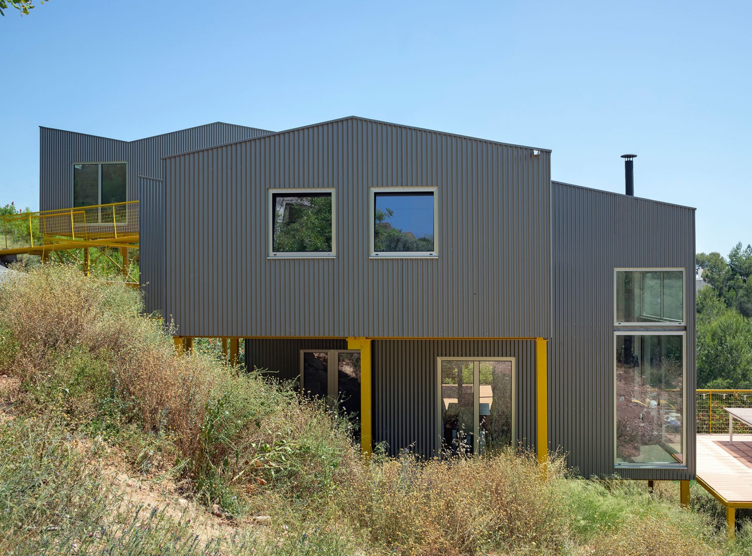 A fragmented house on a slope. rNrH industrialized home by Juan Marco ...