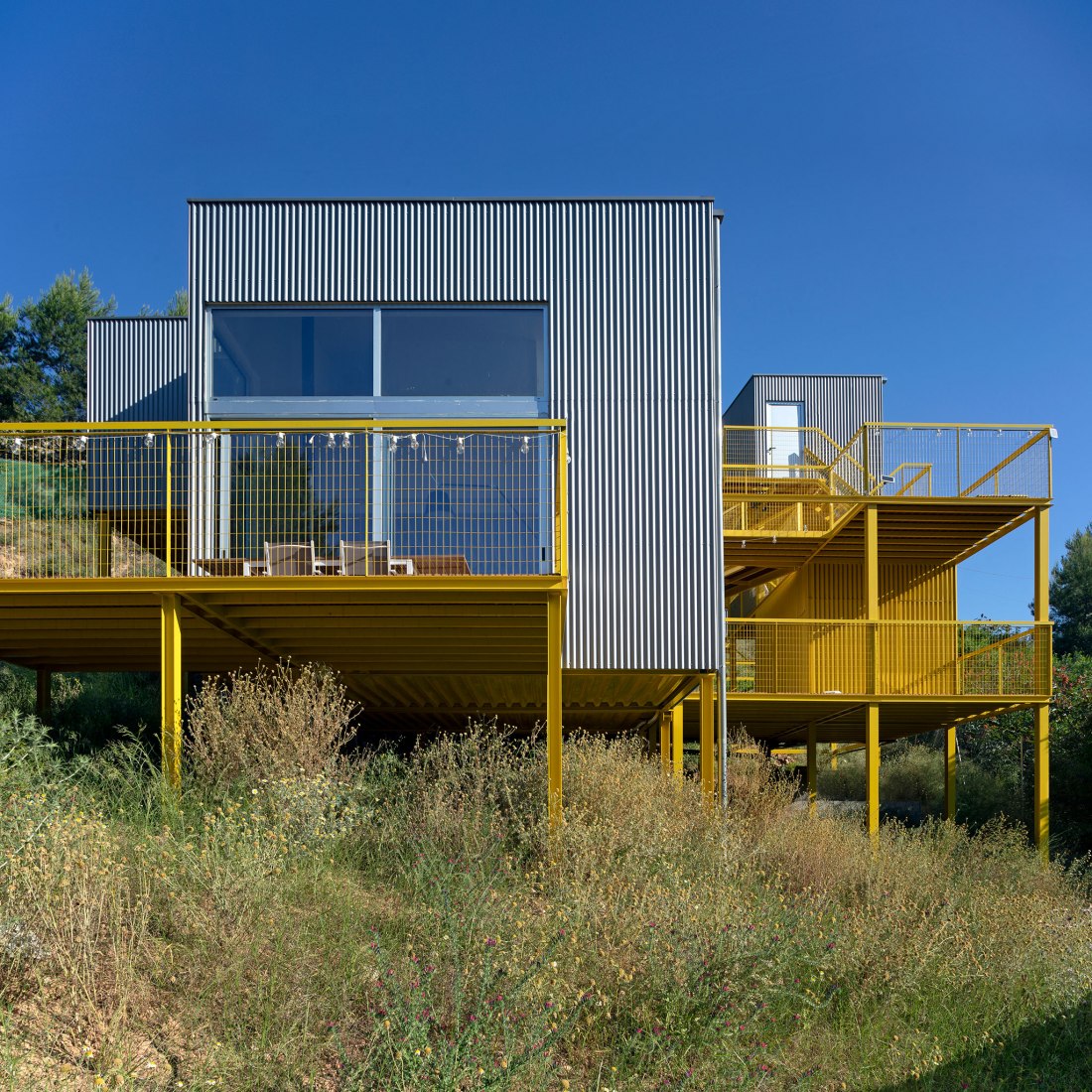 A fragmented house on a slope. rNrH industrialized home by Juan Marco ...