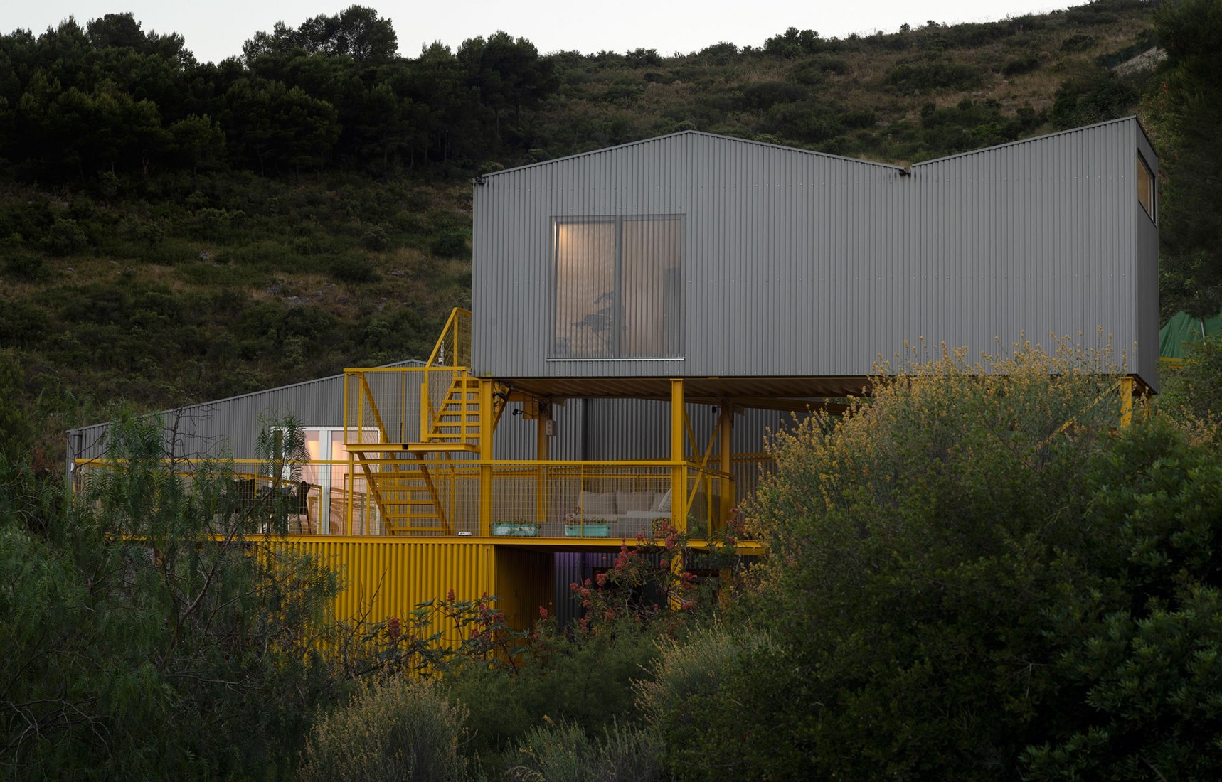 A fragmented house on a slope. rNrH industrialized home by Juan Marco ...